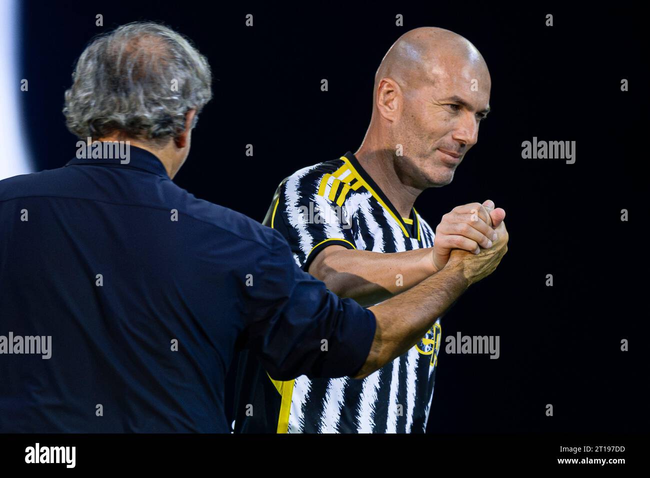 Zinedine Zidane shakes hands with Michel Platini during the 'Together ...