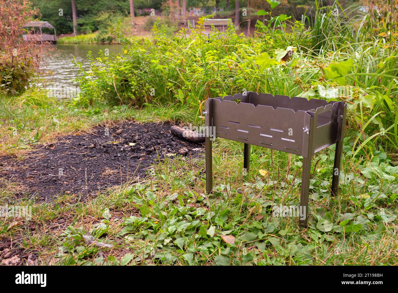 Metal grid in the forest. Barbecue grill on the lawn. Autumn picnic ...