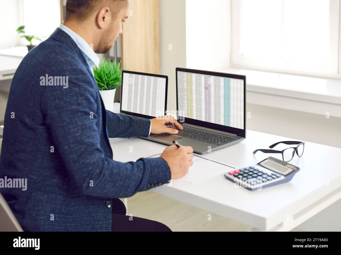 Busy concentrated male financier working in office with Excel ...