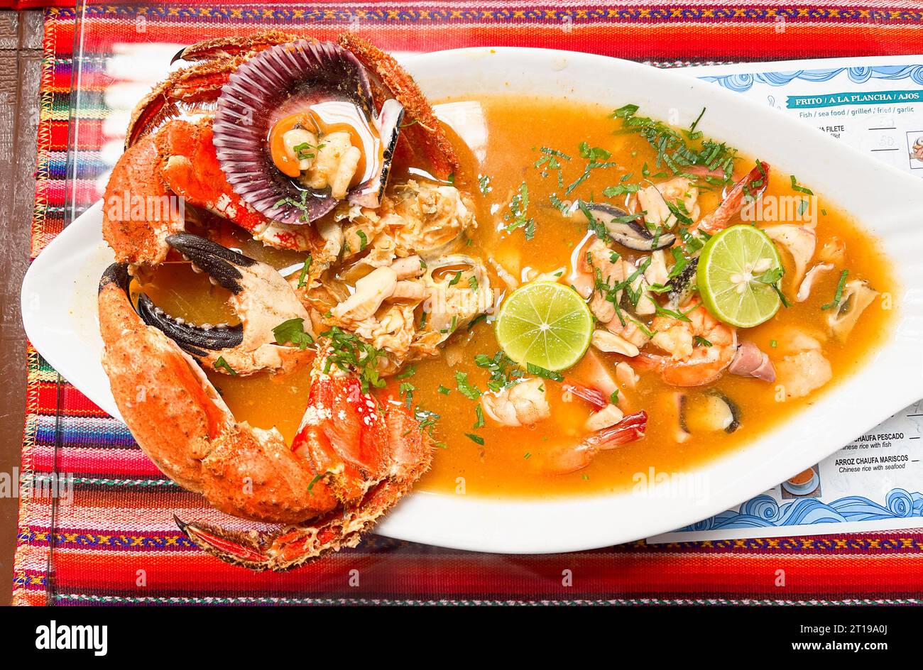 Overhead view of traditional Peruvian soup with crab, fish and lime ...