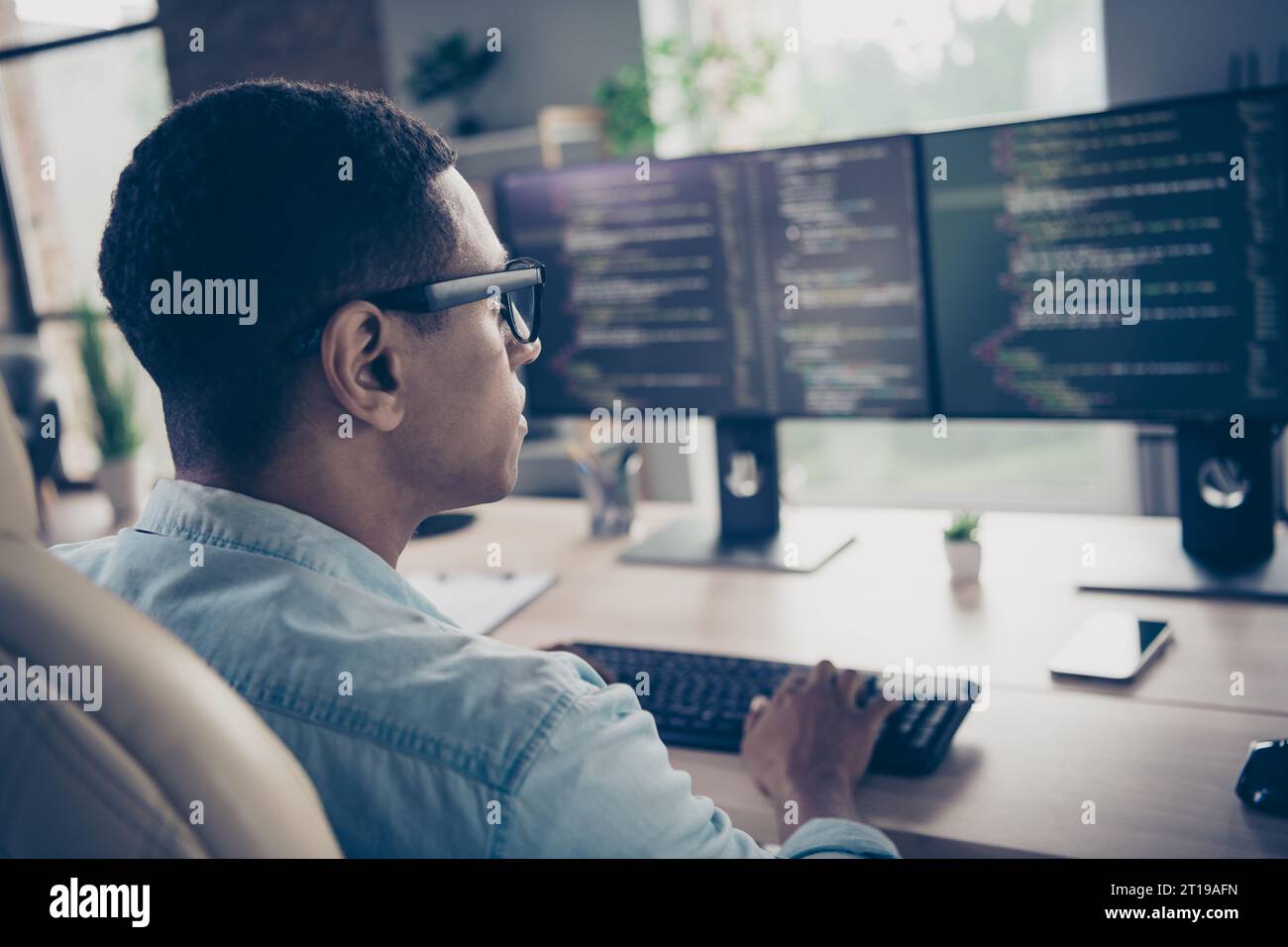 Rear photo of smart skilled young man worker qa engineer testing open ...