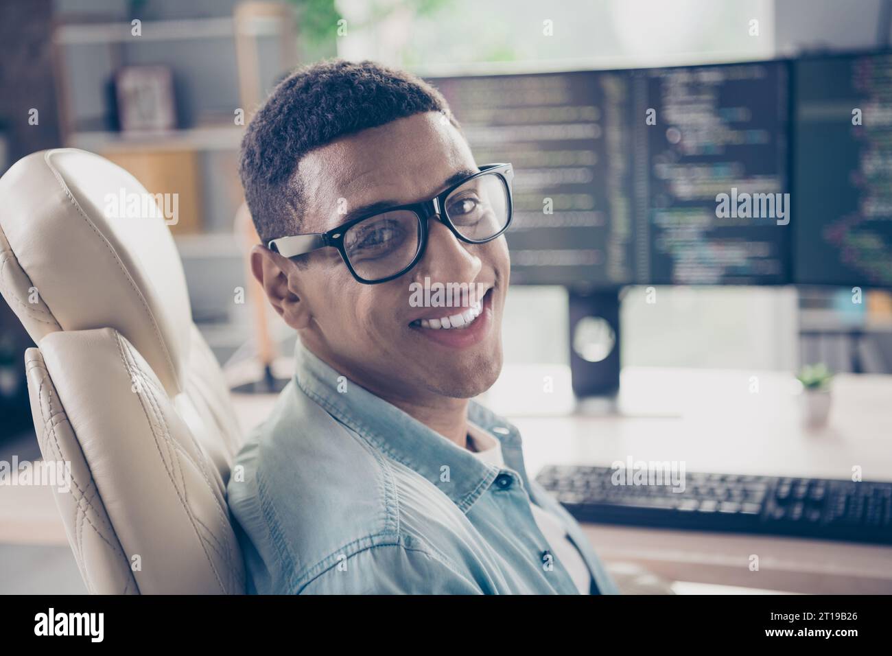 Portrait of young nerd guy hacker sitting leather armchair when fixing bugs in his code at ...