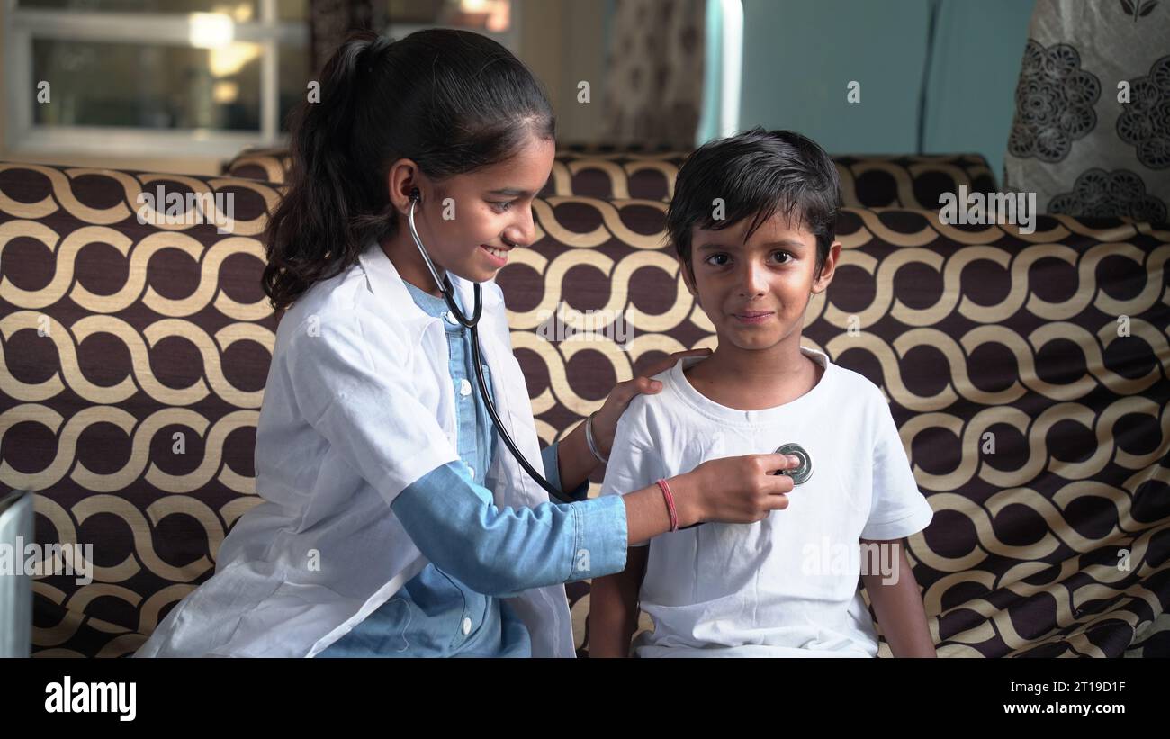 Happy child smiling while doctor is examining her lungs or heart during ...