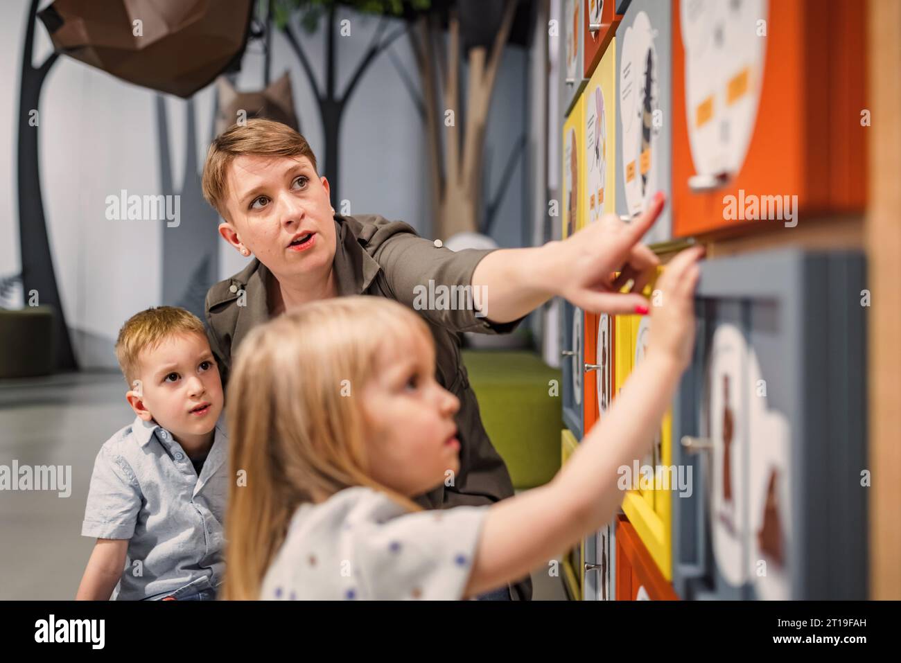 Mother playing discovery games with two little children in an ...