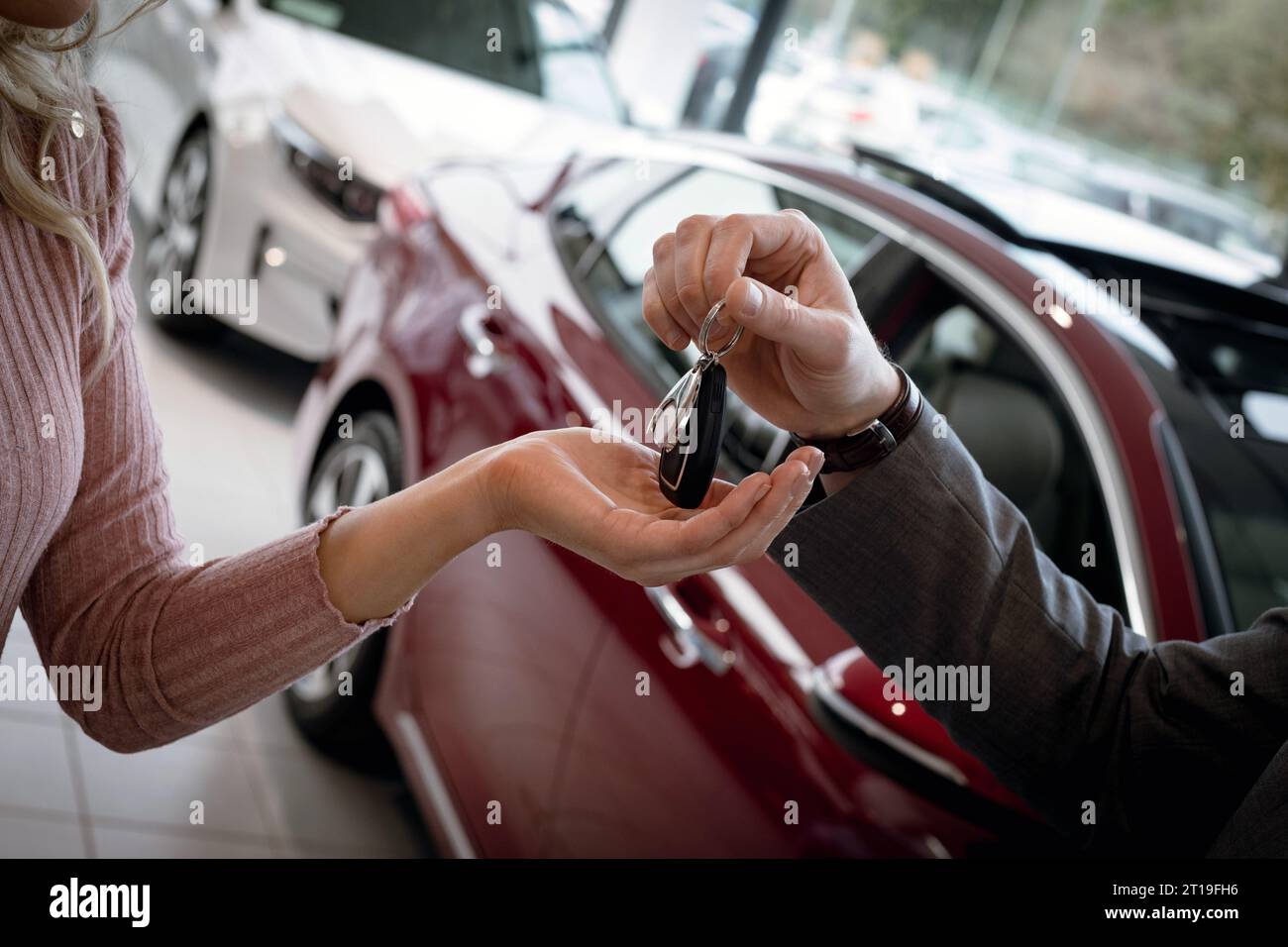 Buy a car conceptual background. Give a new car keys in a car salon ...