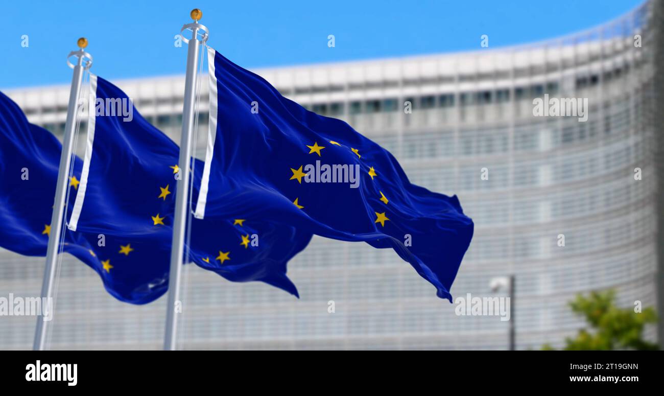 European union flag waving with European Commission headquarters ...