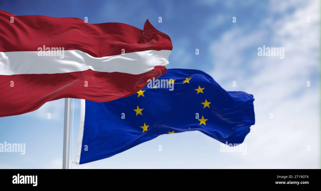 Flags of Latvia and the European Union waving on a clear day. Latvia is ...