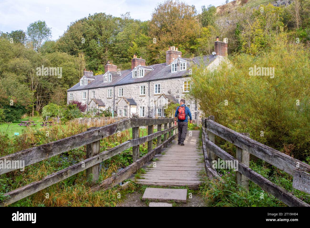 Backpacker walking over Footbridge across the river Wye at Blackwell ...