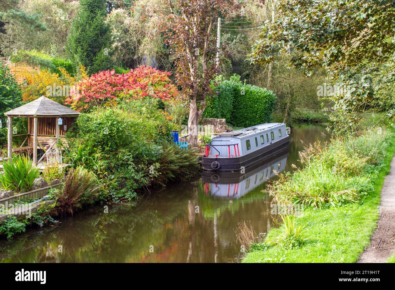 Canal narrowboat moored alongside gardens on the Caldon canal in the ...