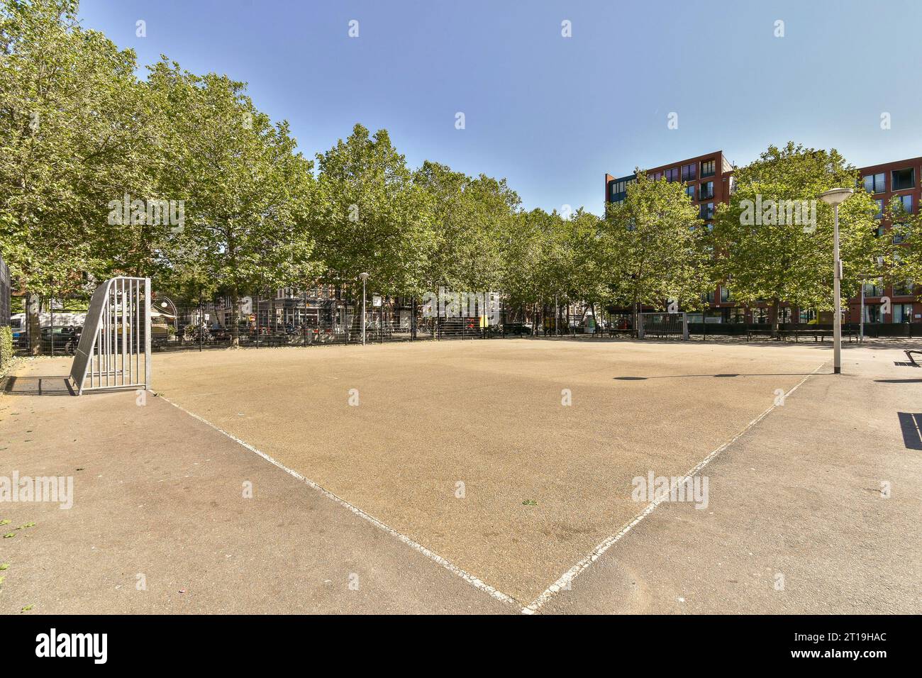 an empty parking area with trees and buildings in the background on a ...