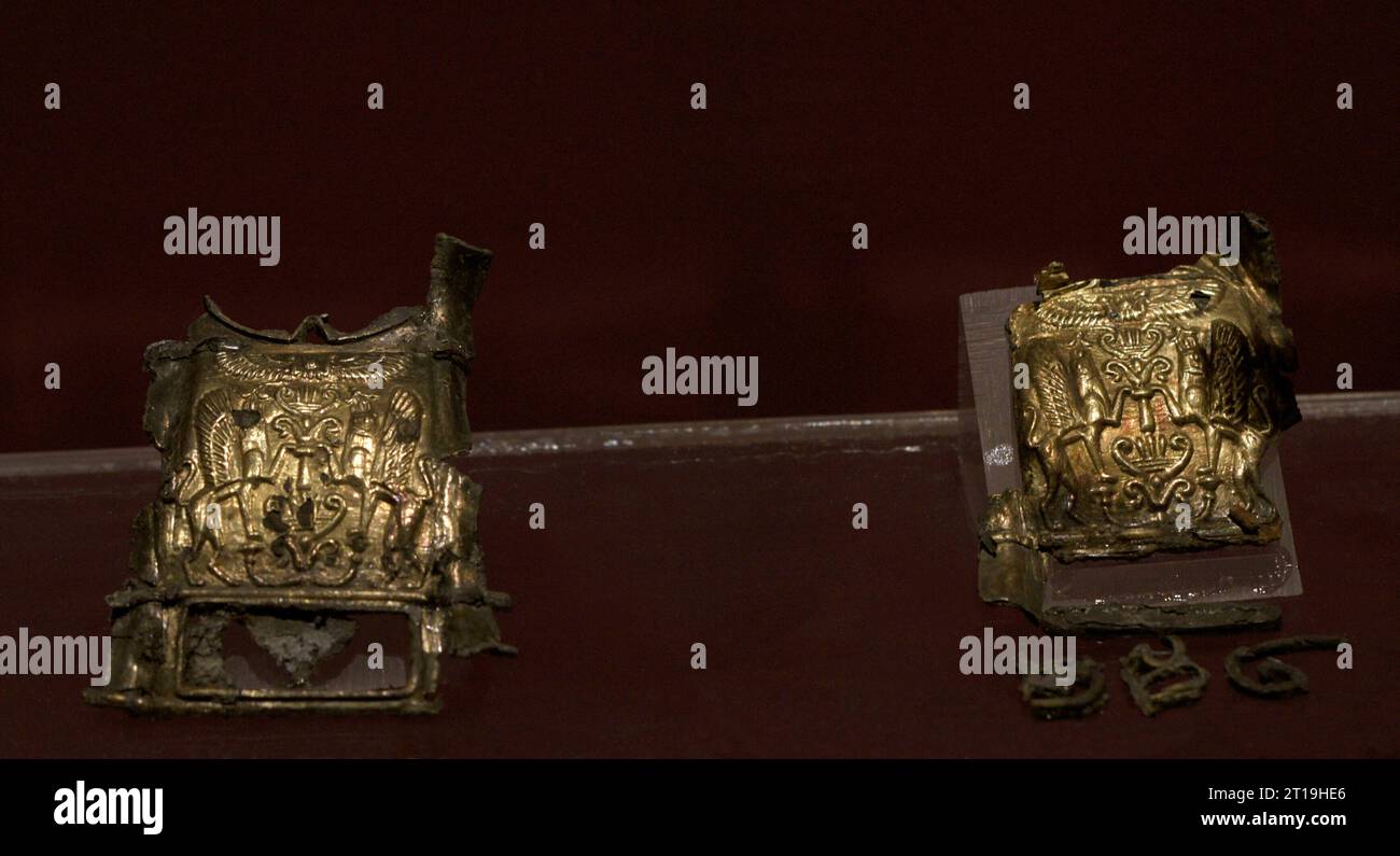 Belt buckles or armbands with two griffons flanking a palmette with ...