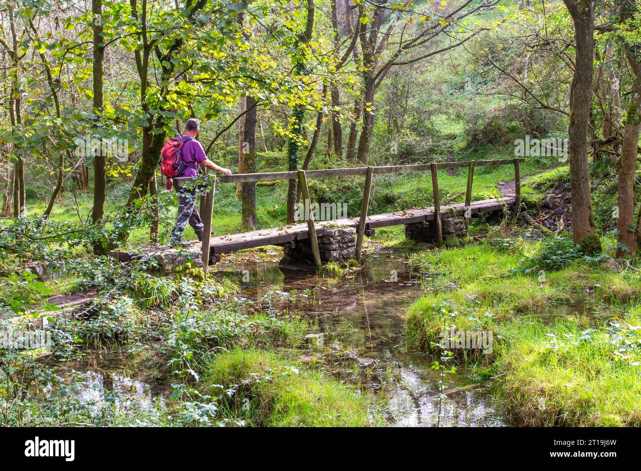 Man walking backpacking over the footbridge at the Miller's Dale end of ...