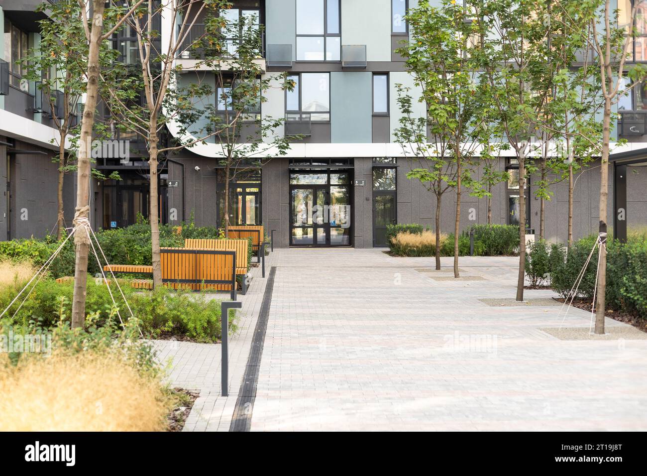 cozy courtyard with benches, trees near the high-rise city house Stock ...