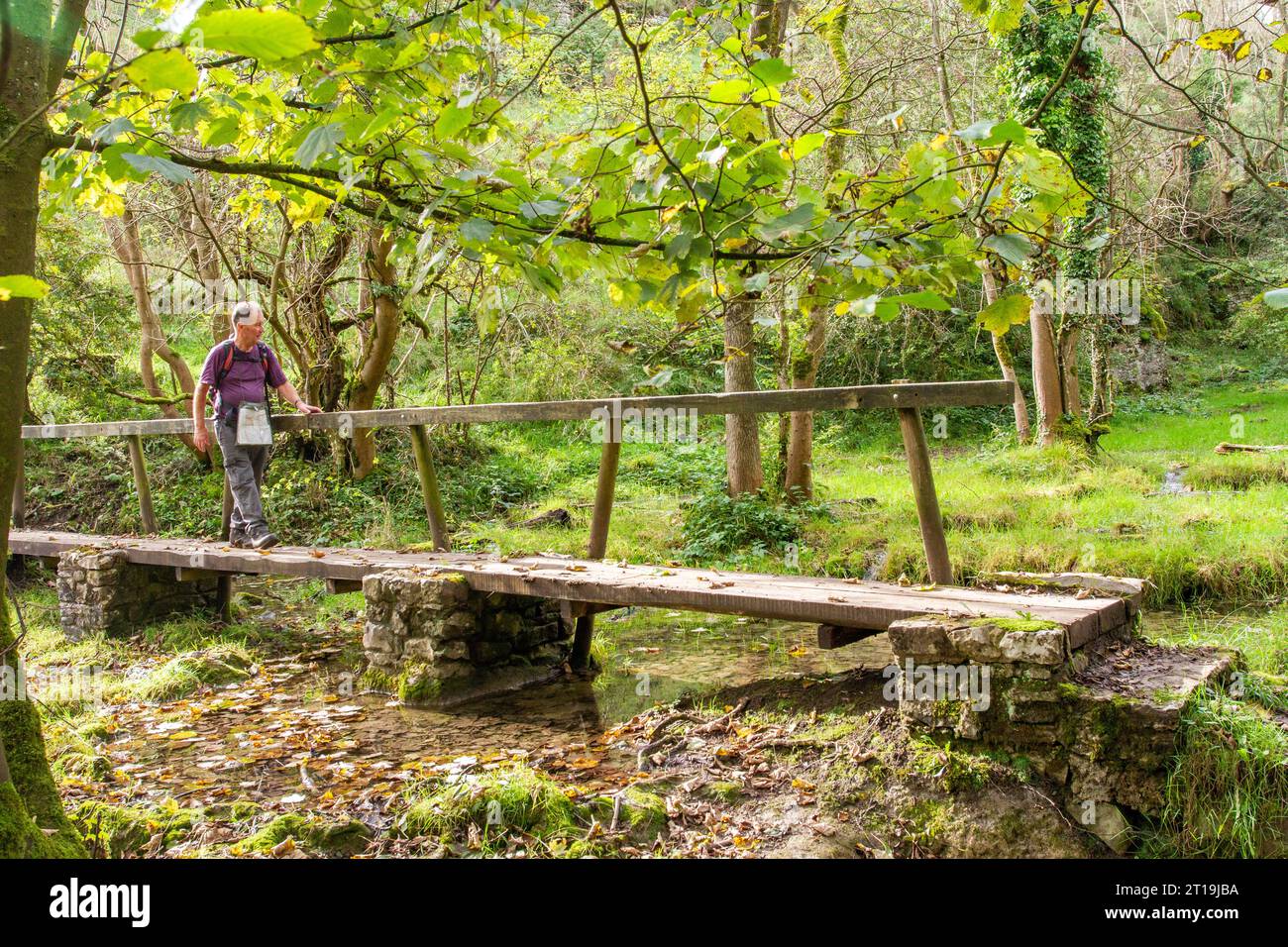 Man walking backpacking over the footbridge at the Miller's Dale end of ...