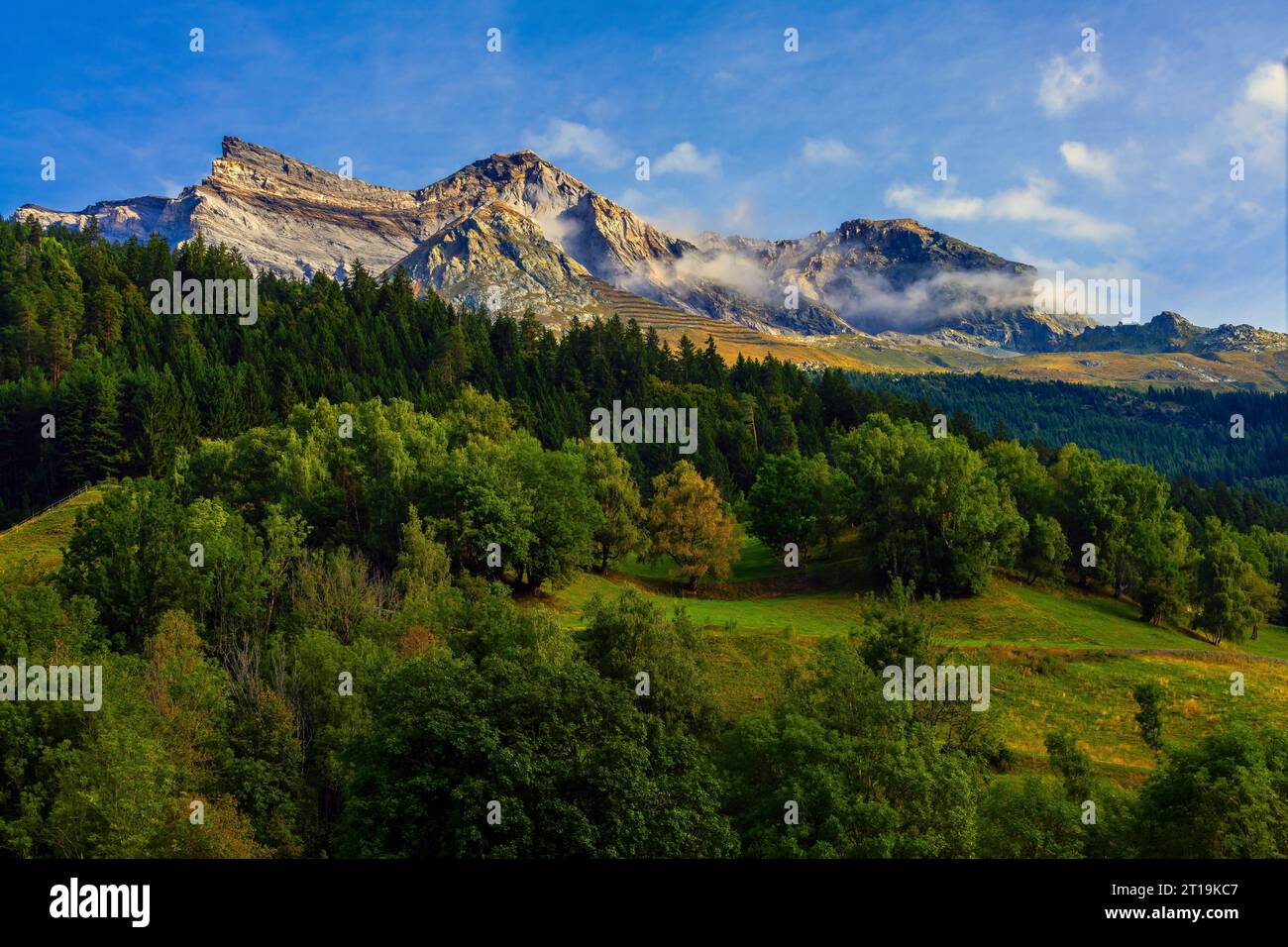 Classic alpine landscape, green meadows with high rocky mountains in ...