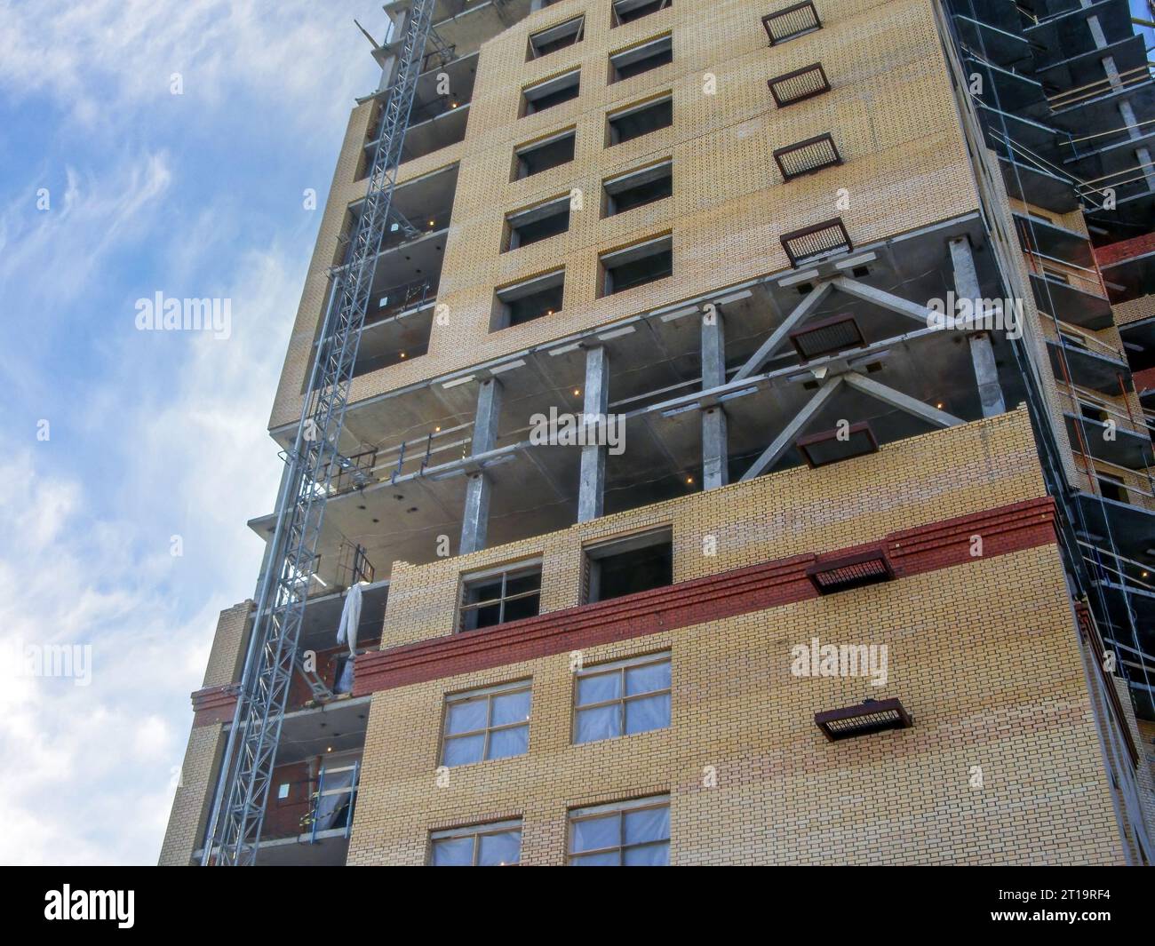 View of the high-rise building under construction. Brick walls and ...