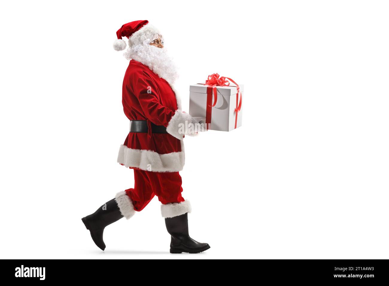 Full length profile shot of santa claus walking and carrying a present ...