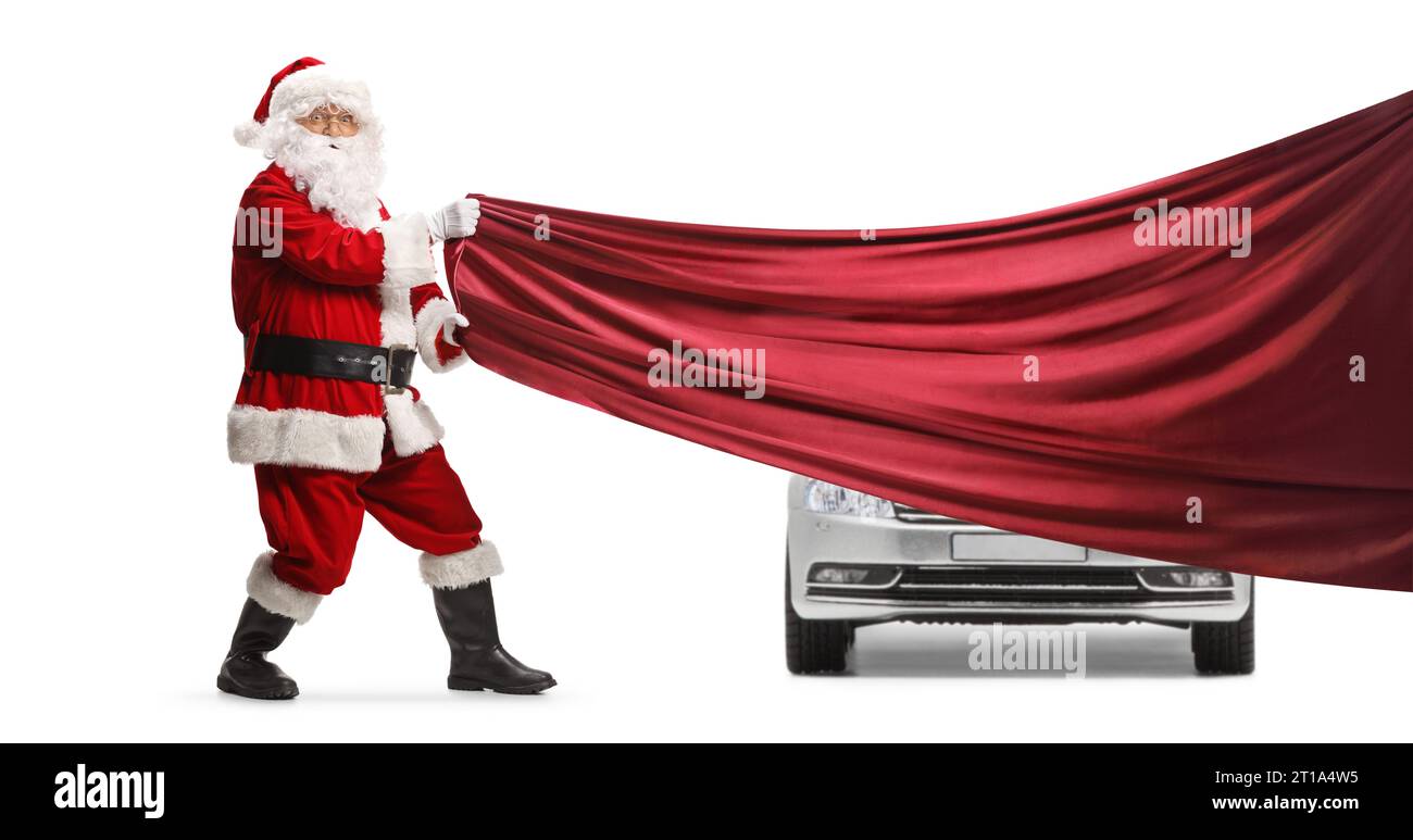 Santa Claus pulling a red piece of cloth in front of a new car isolated ...
