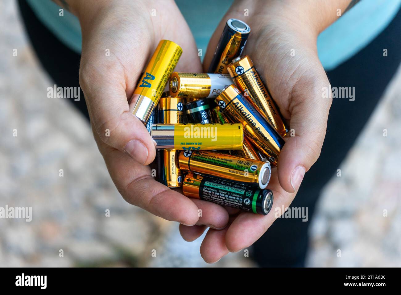 Hands holding stacks of batteries ready for recycling Stock Photo - Alamy