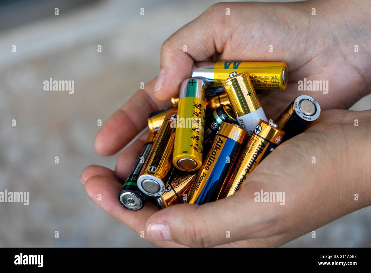 Hands holding stacks of batteries ready for recycling Stock Photo - Alamy