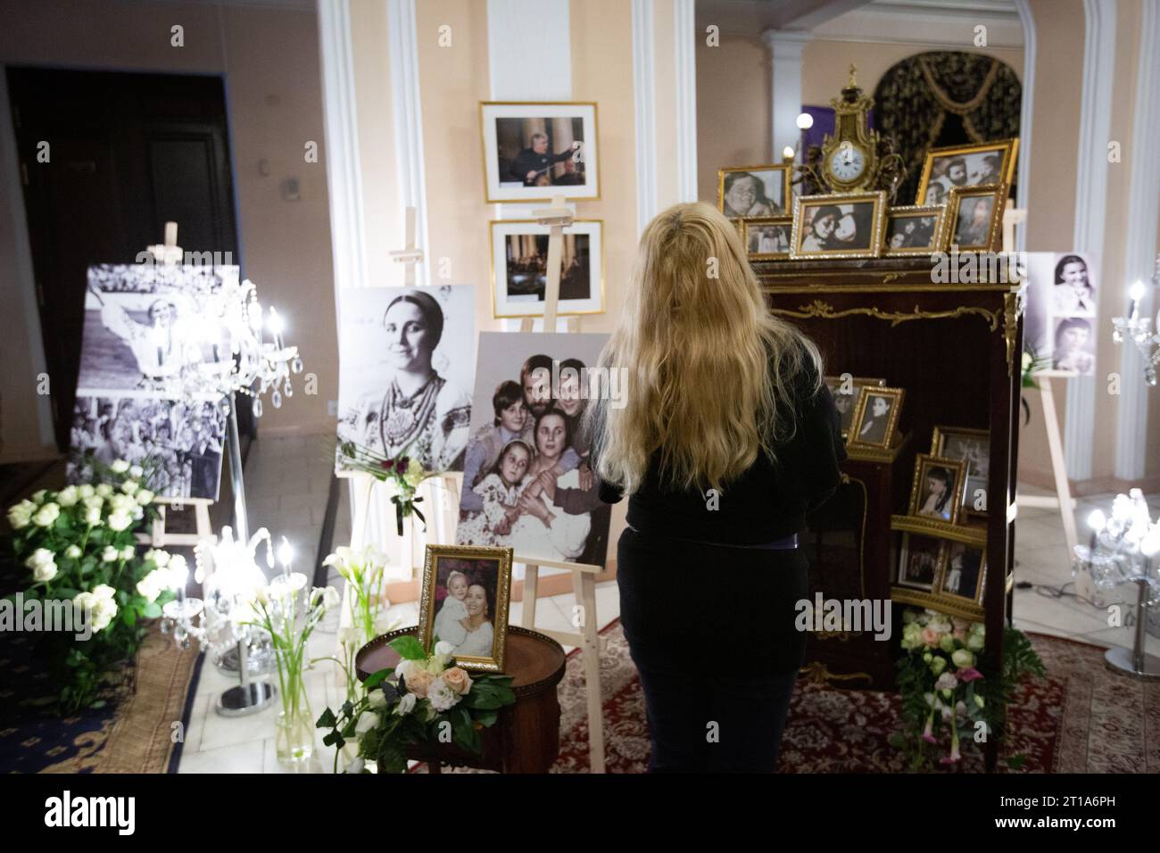 A woman looks at photographs of the deceased singer during the funeral ...
