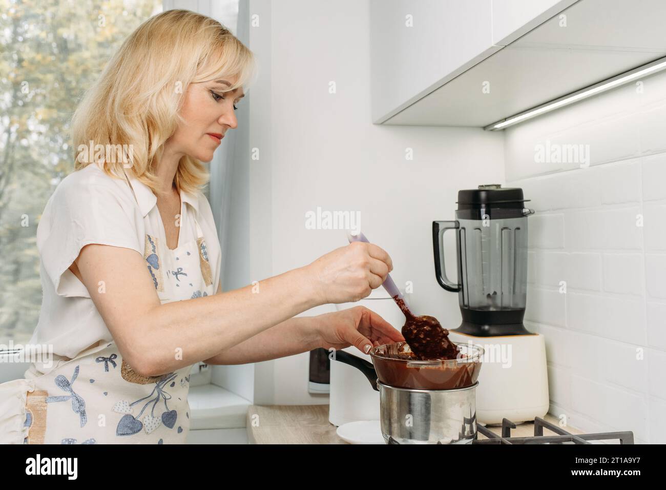 The pastry chef mixes melted chocolate. Horizontal plan Stock Photo - Alamy