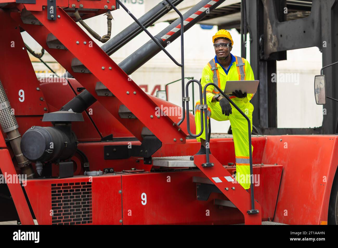 African male dock worker control loading containers cargo at warehouse ...