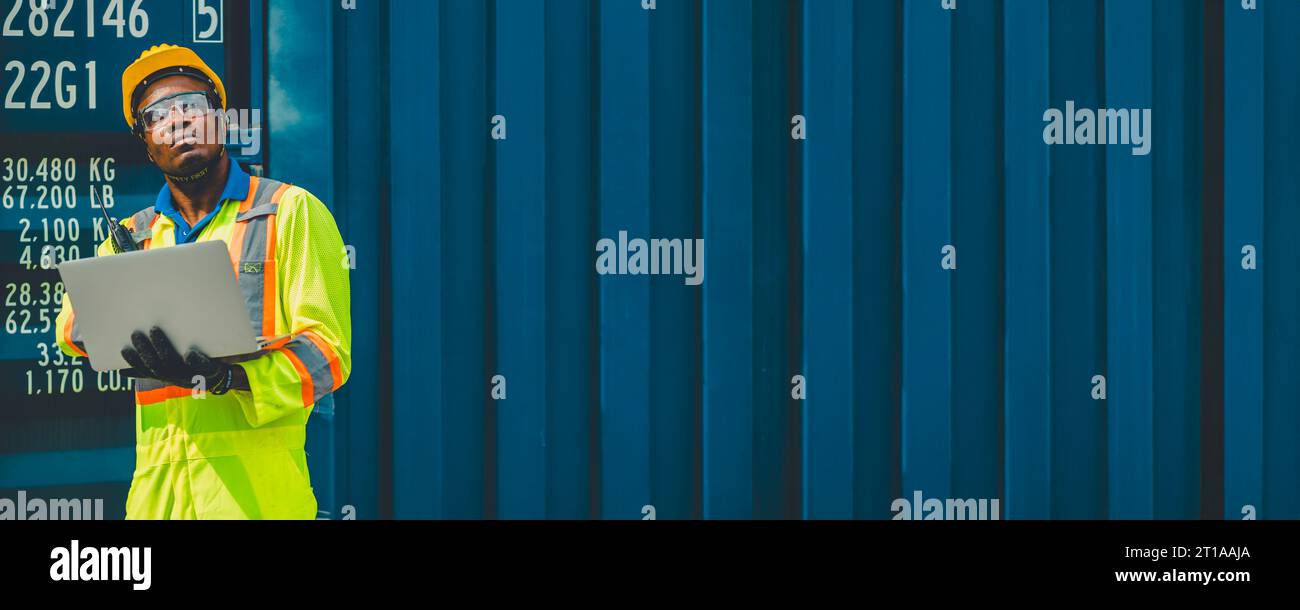 African black shipping worker in cargo port container yard with wide ...