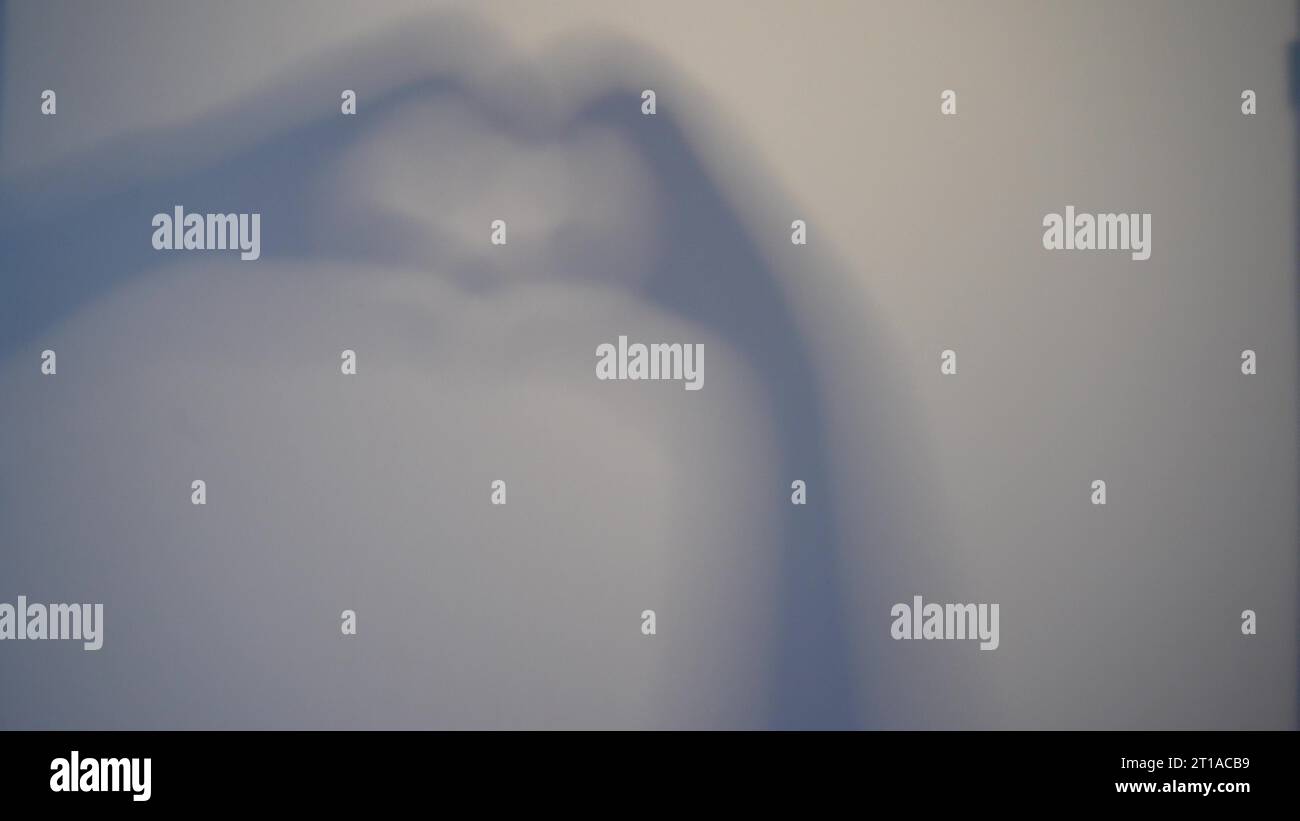 Shadow Blur of a horror man behind frosted glass. Blurred hand, body shape abstraction and one ...