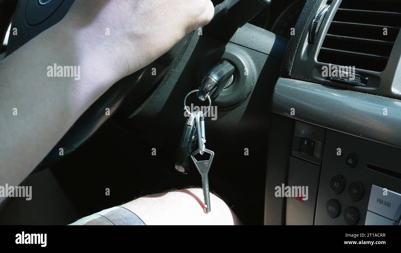 Keys in the ignition. Close-up of a key in a car ignition. Man's hand ...