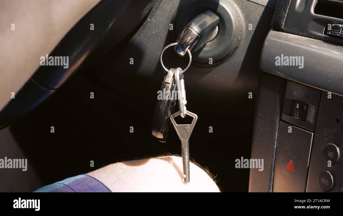 Keys in the ignition. Close-up of a key in a car ignition. Man's hand ...
