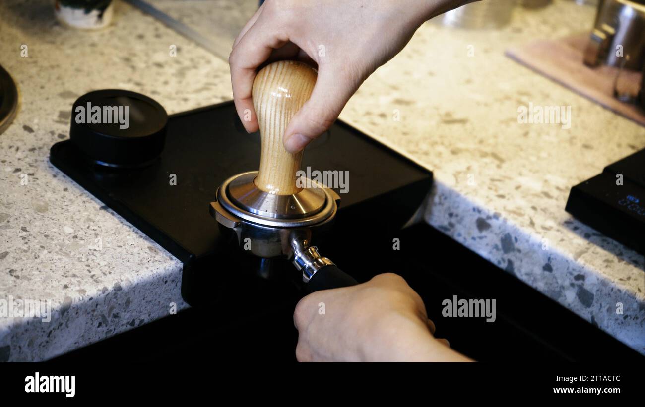 Preparation of ground coffee with tamping of fresh coffee. Tamper of ...