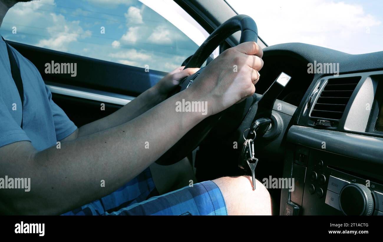 Keys in the ignition. Close-up of a key in a car ignition. Man's hand ...