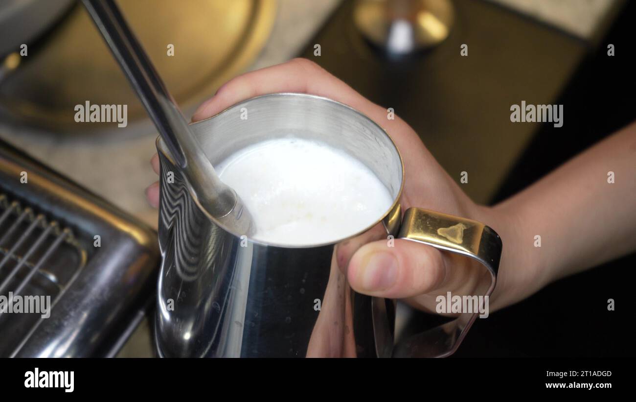 The barista steams the milk. The process of creating milk foam. Latte ...