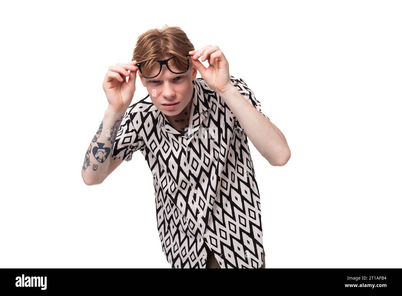 young upset angry caucasian ginger man with a tattoo on his arms is ...