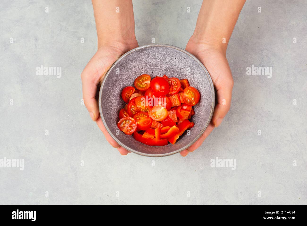 Tomatoes and red sliced pepper pieces in a bowl, prepare healthy food ...