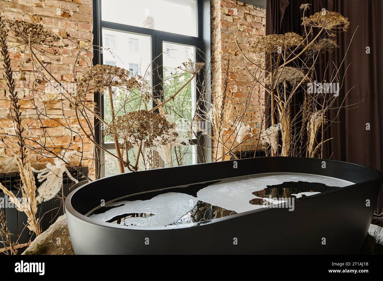 water inside of black bathtub in modern apartment with windows and ...