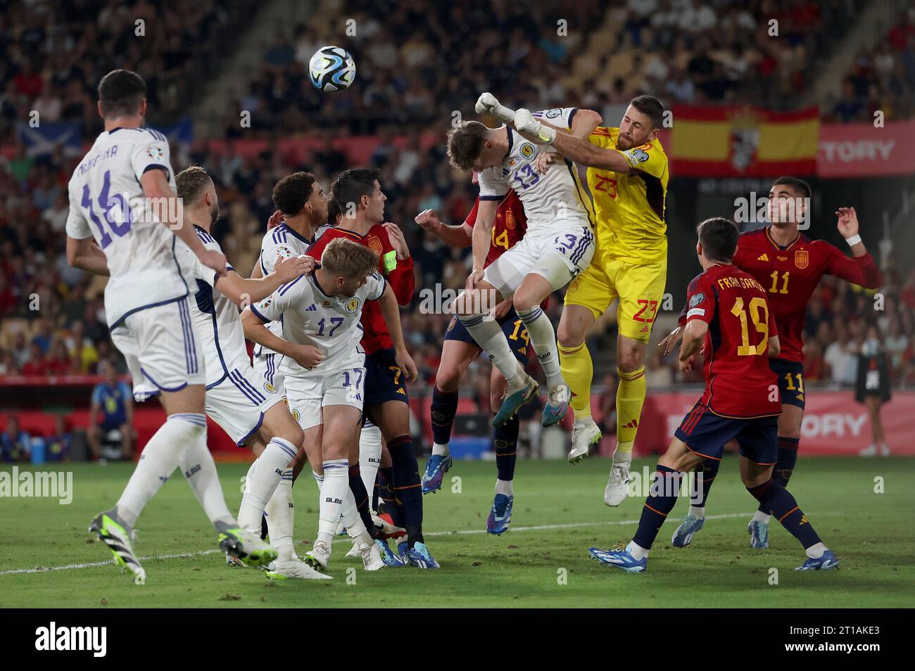 Spain goalkeeper Unai Simon punches clear from Scotland's Jack Hendry ...