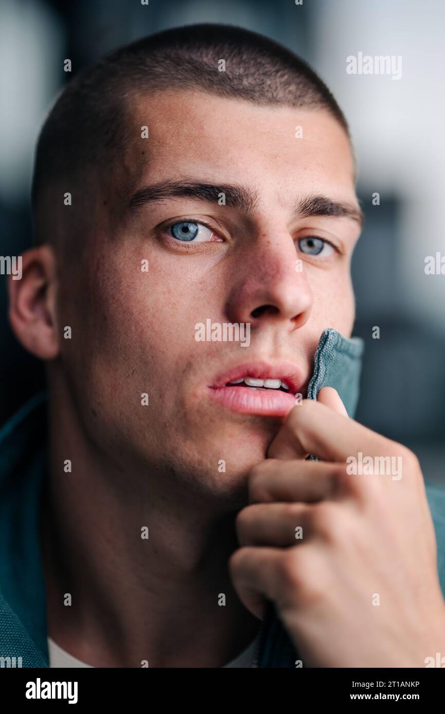 A close-up portrait of a handsome young man with striking green eyes ...