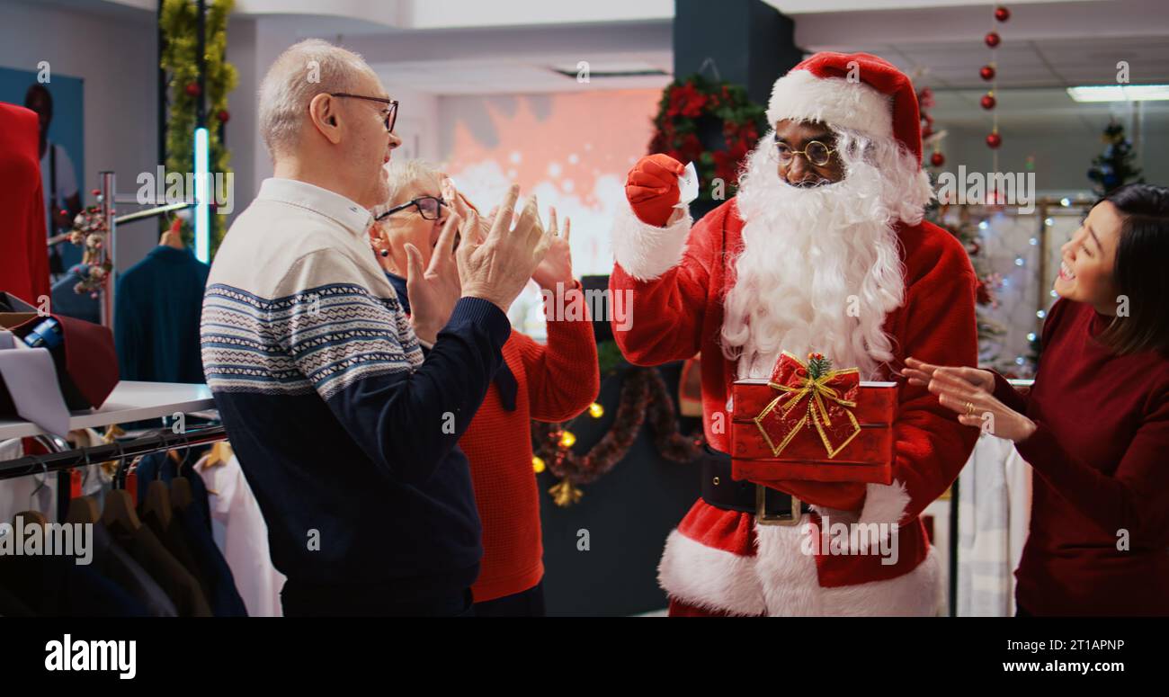 Retail assistant wearing Santa Claus suit in holiday adorn fashion ...