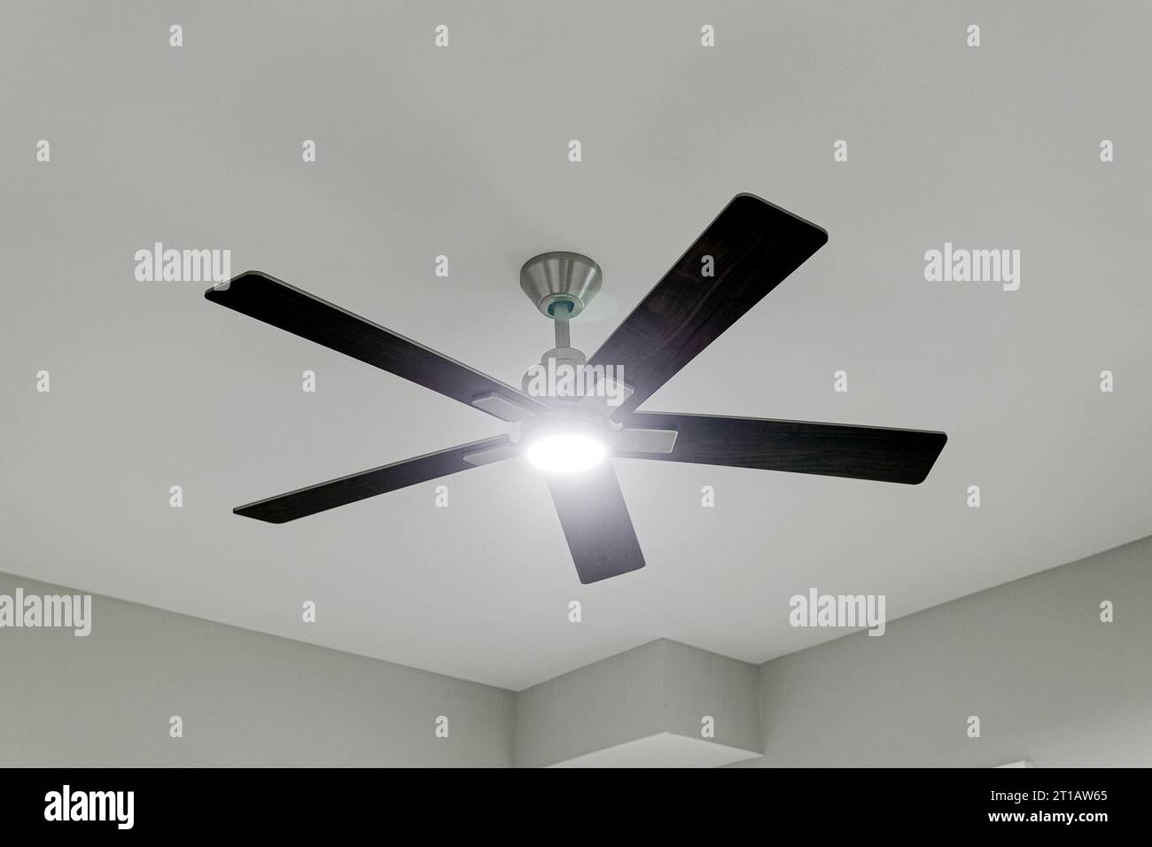 Glowing Ceiling Fan with Wood Arms and Chrome Accents on Clean Ceiling ...
