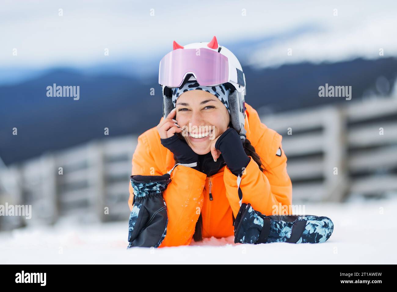 Skier girl posing laying on the snow Stock Photo - Alamy