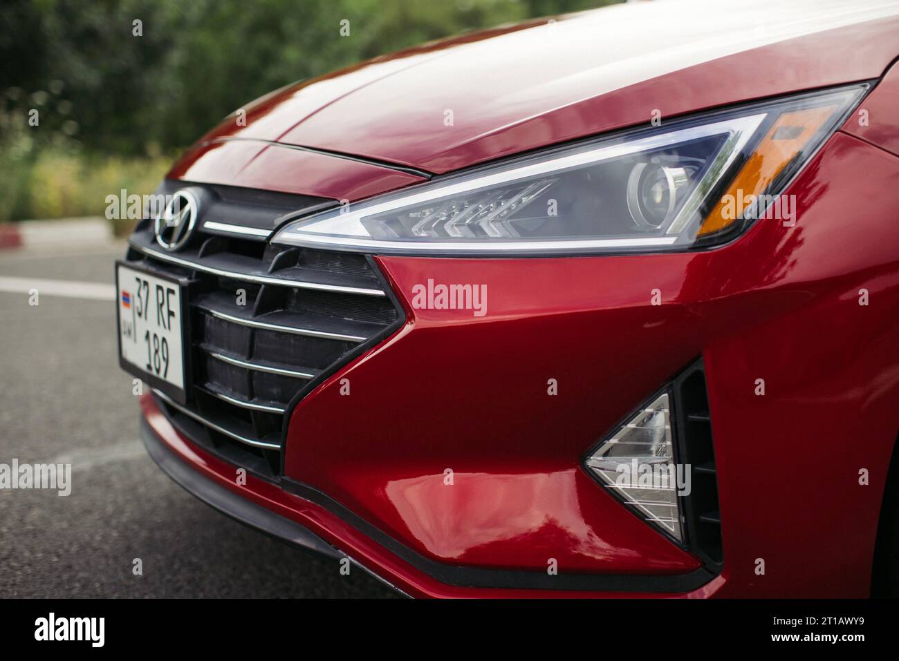 A brand new red Hyundai car gleaming in the sunlight parked in a lot ...