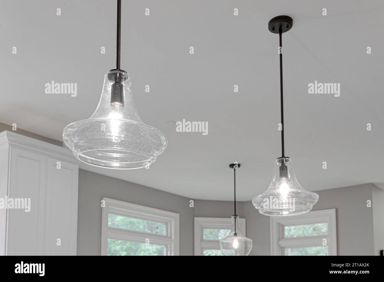 Clear Penant Lights Over Kitchen Island with Black Metal Rod in Blank ...