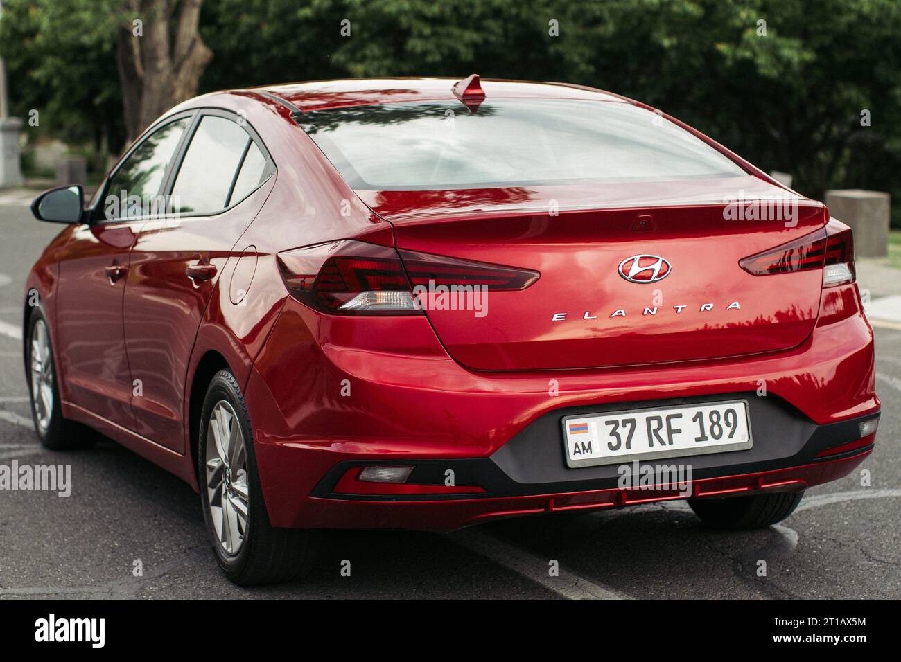 A brand new red Hyundai car gleaming in the sunlight parked in a lot ...