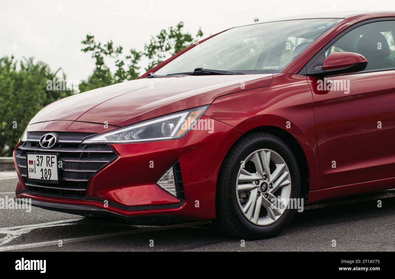A brand new red Hyundai car gleaming in the sunlight parked in a lot ...