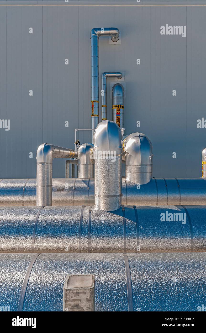 Reflective metallic insulated piping on the roof of a cold-storage ...