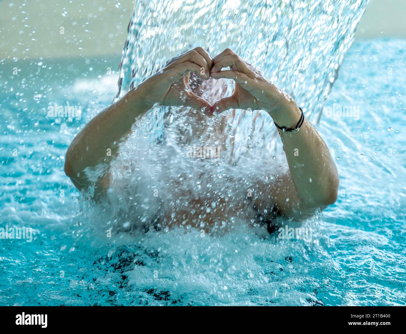 Woman Behind a Waterfall in a SPA Swimming Pool and Making a Heart ...