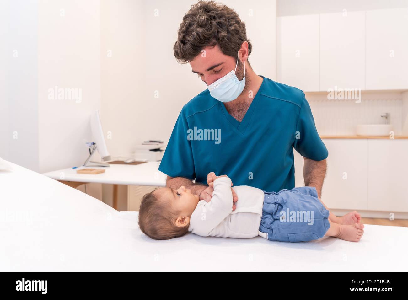 Adorable newborn baby lying on stretcher while getting examined by a ...