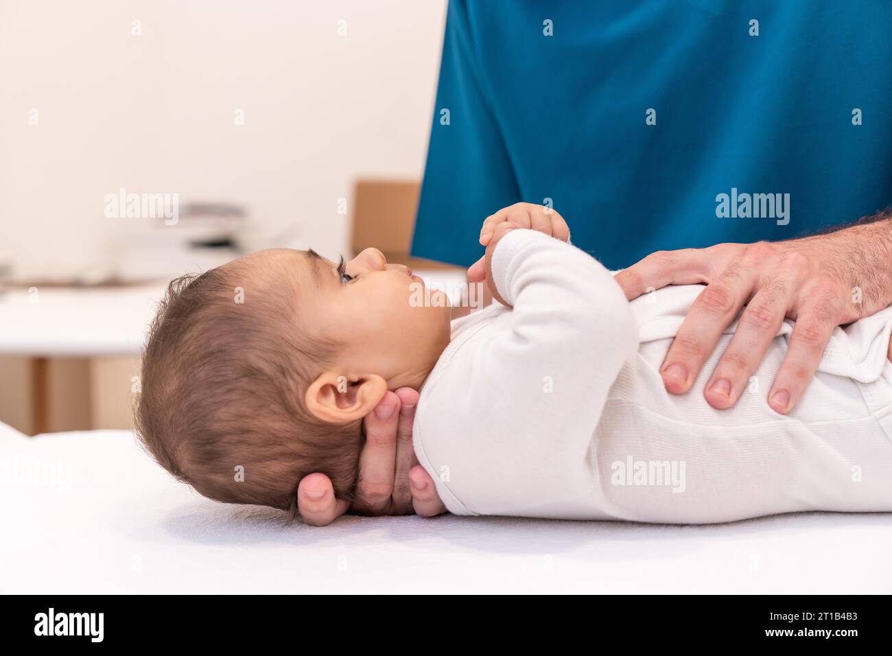 Close-up photo of an unrecognizable doctor examining baby in office ...